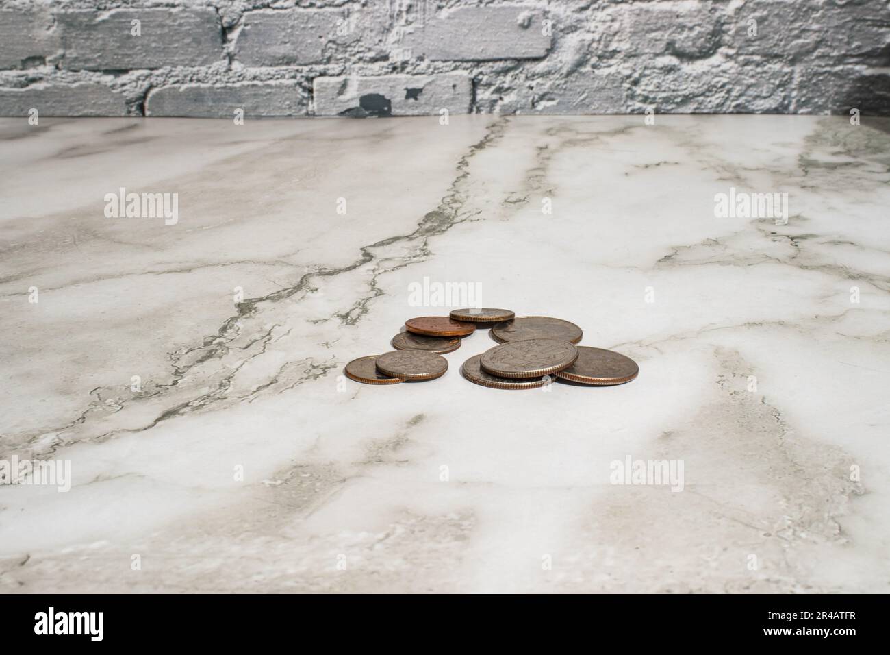 A pile of several coins sitting atop a marble countertop Stock Photo ...