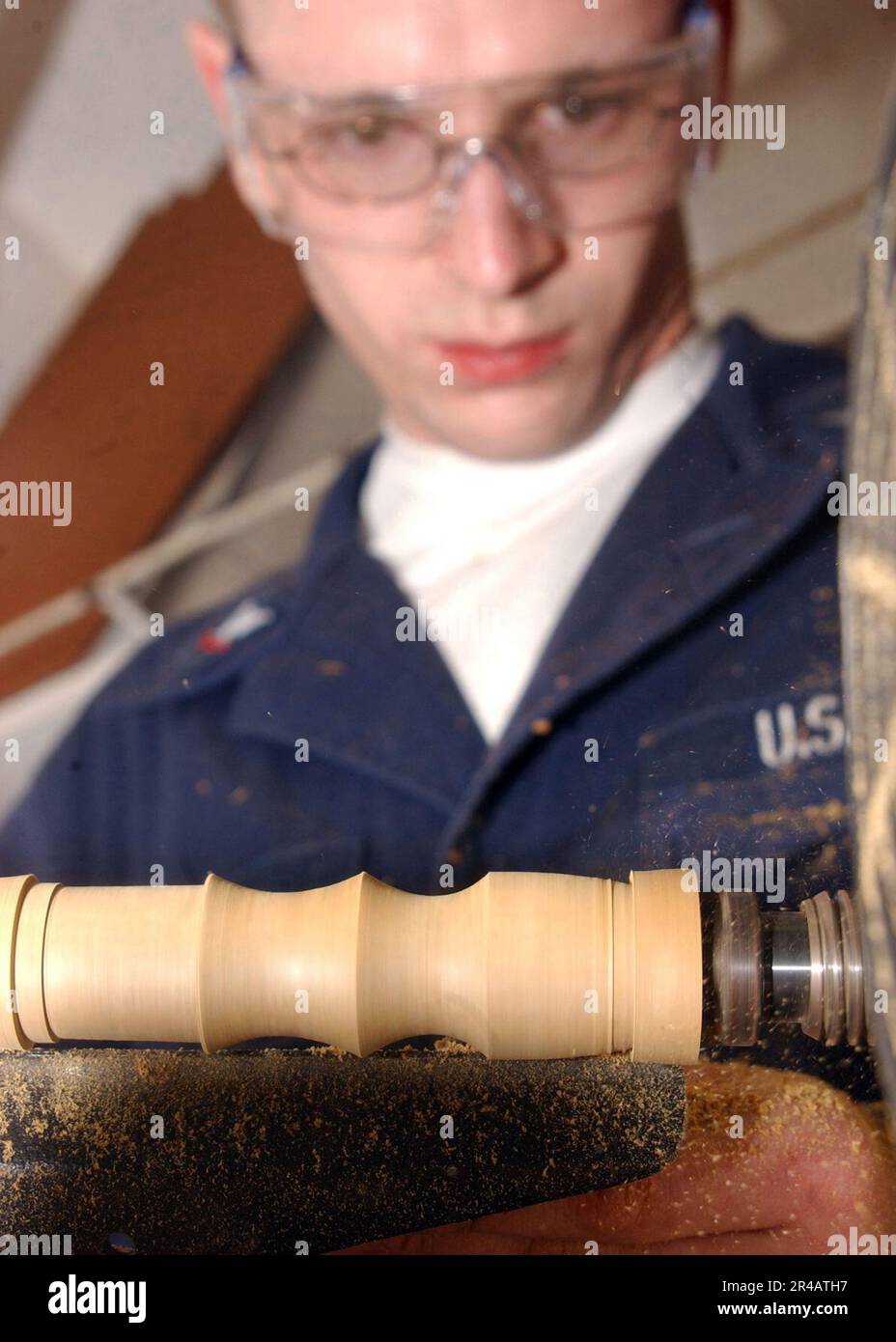 US Navy Hull Maintenance Technician 3rd Class uses a lathe to fashion a ...