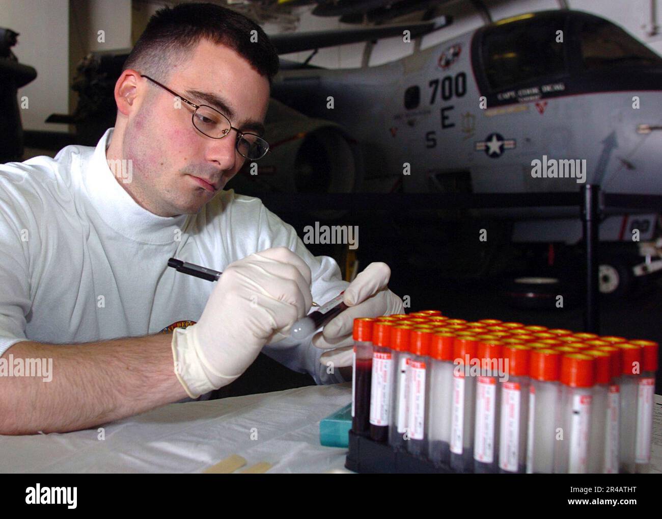 US Navy Hospital Corpsman 3rd Class labels blood samples taken during ...
