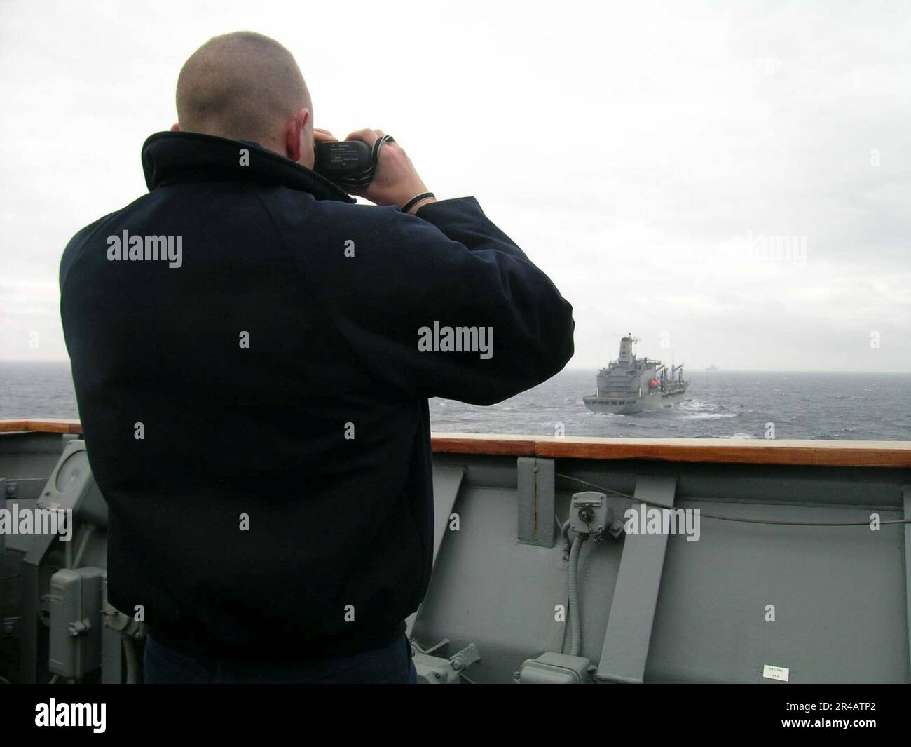 US Navy Ens. stands watch as Conning Officer aboard the amphibious dock ...