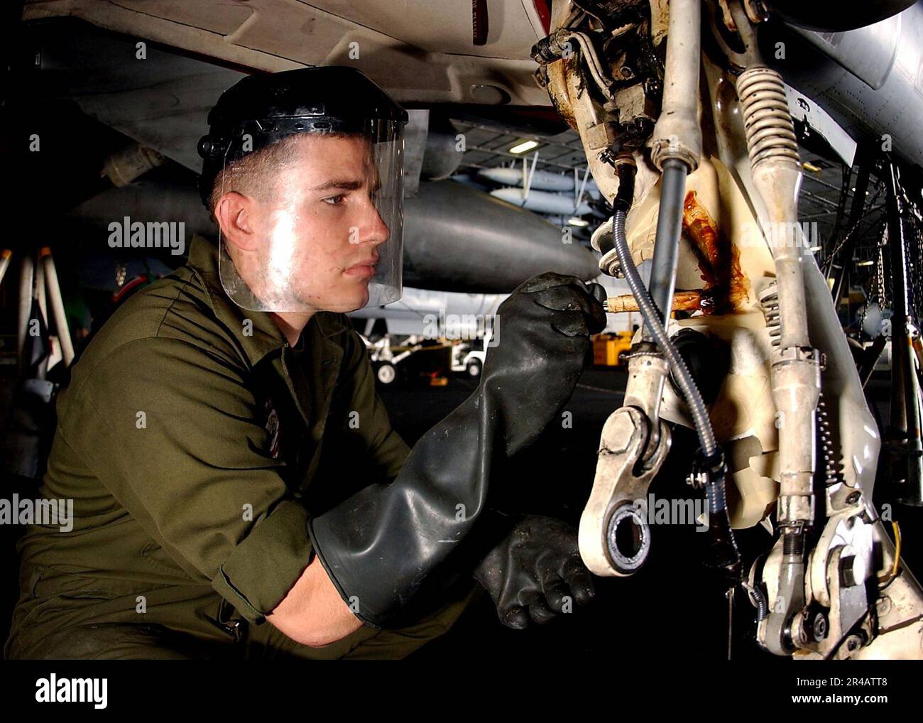 US Navy Marine Corps Cpl. uses solvent to remove paint from a main ...