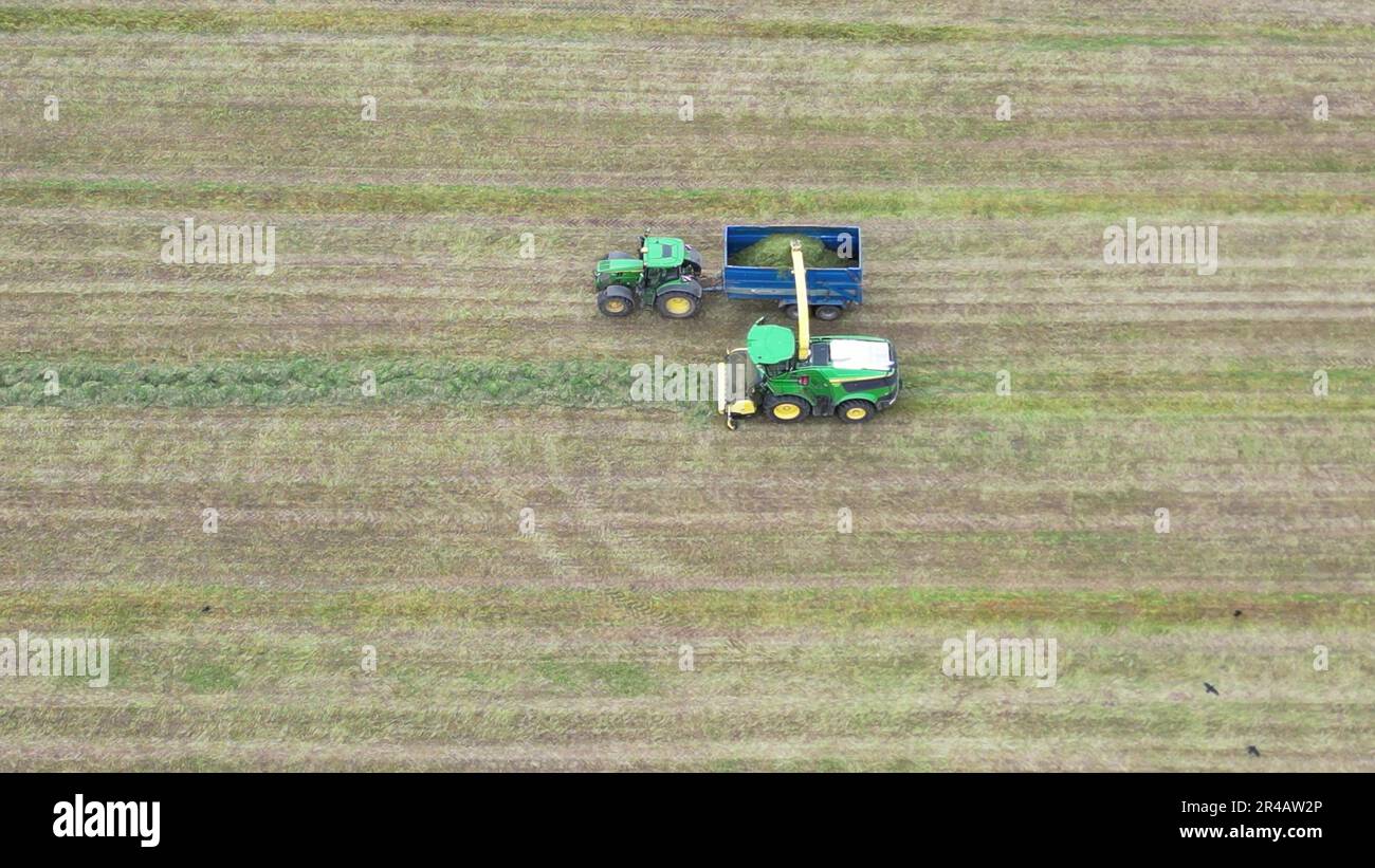 An aerial view of agricultural tractors working on a grassy field Stock ...