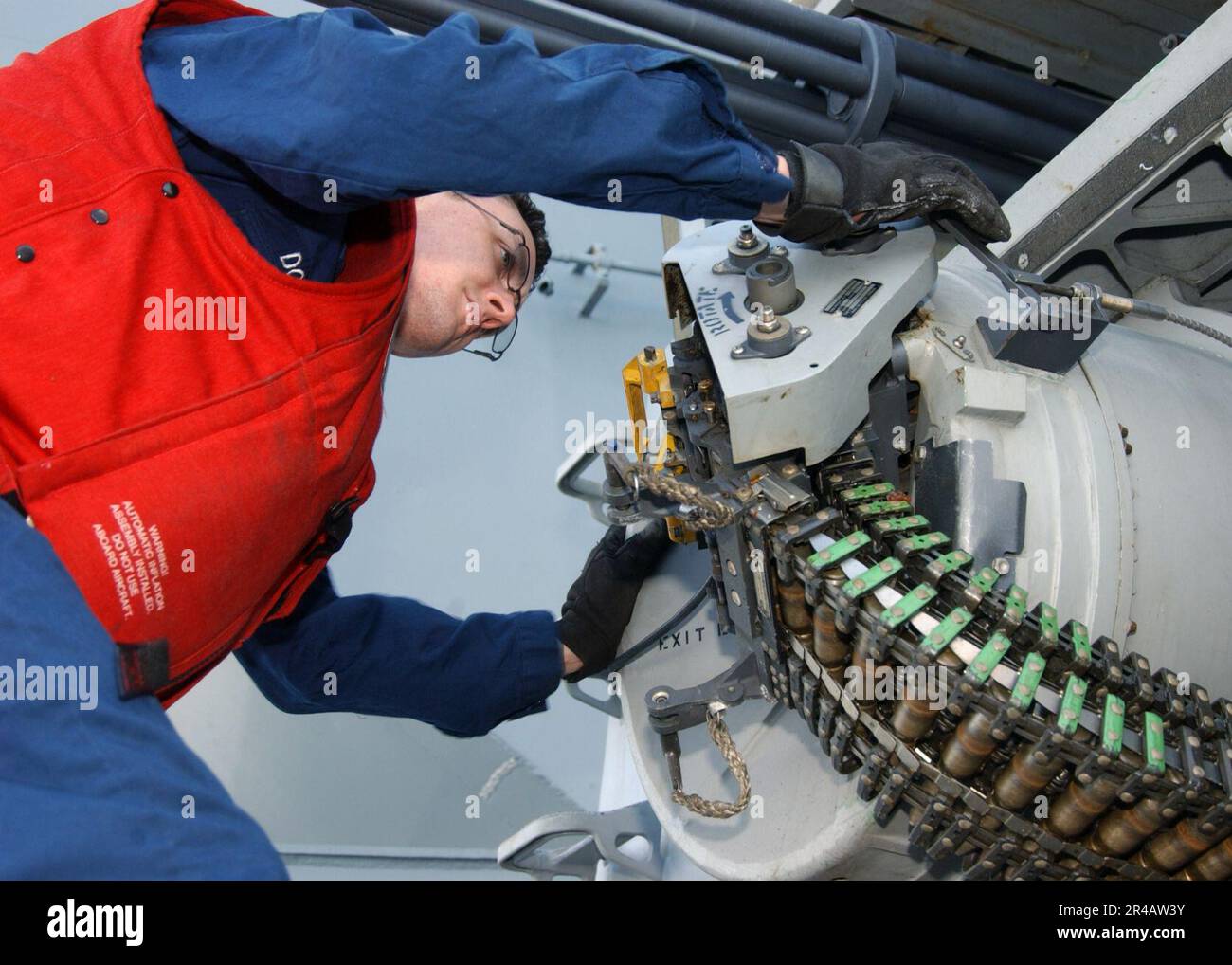US Navy Fire Controlman 3rd Class attaches a loader assembly to a Close ...
