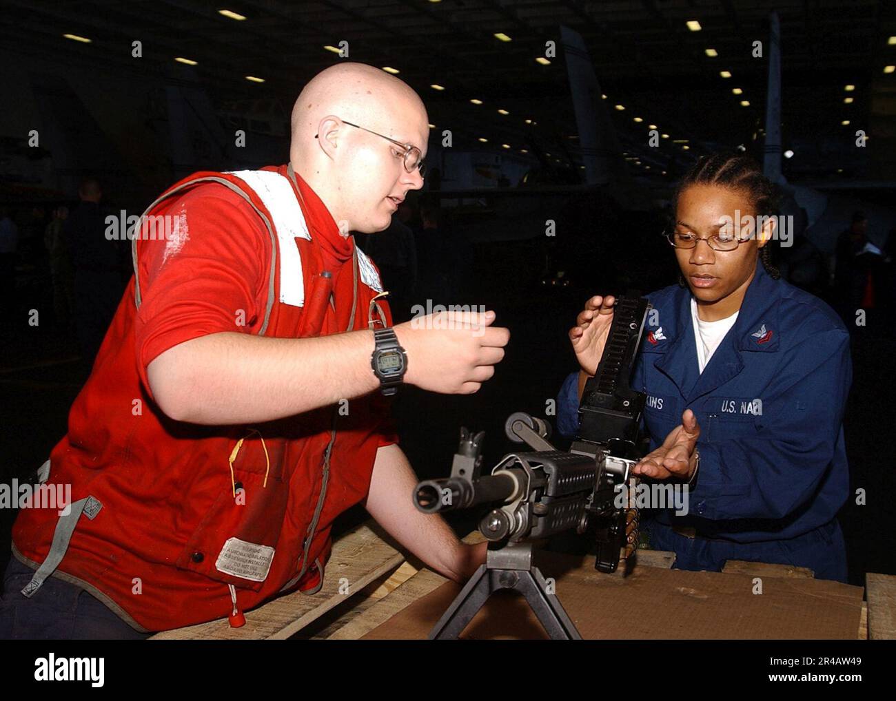 US Navy Torpedoman's Mate 2nd Class instructs a Sailor on the proper ...