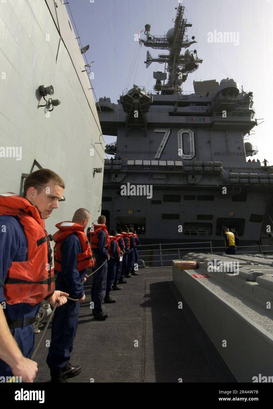 US Navy Line handlers use teamwork to heave the shot line from the ...
