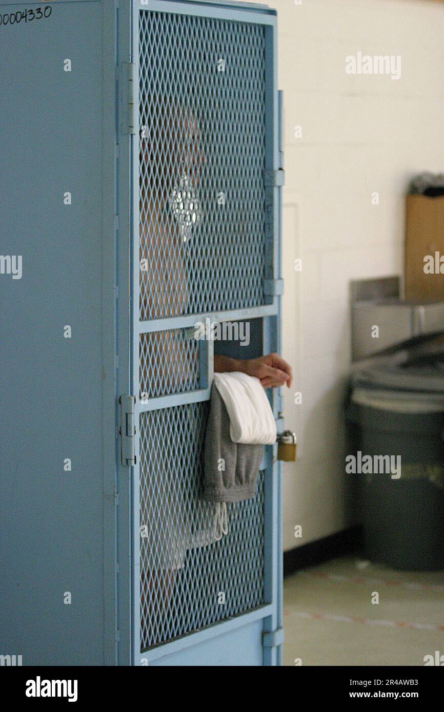 A person is seen sitting inside a locker in a gymnasium, wearing a ...