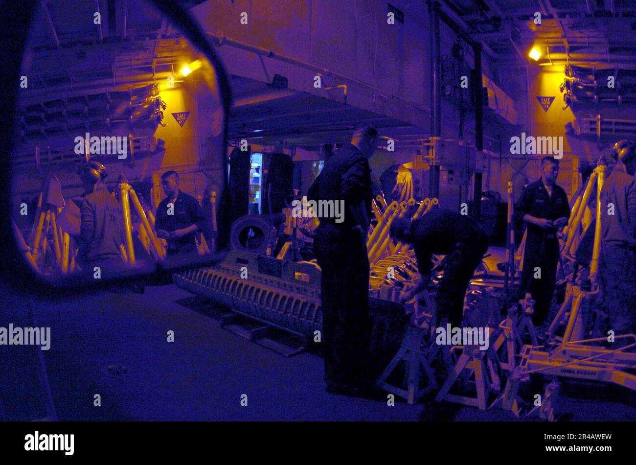 US Navy Personnel work in the hangar bay through the night, preparing ...