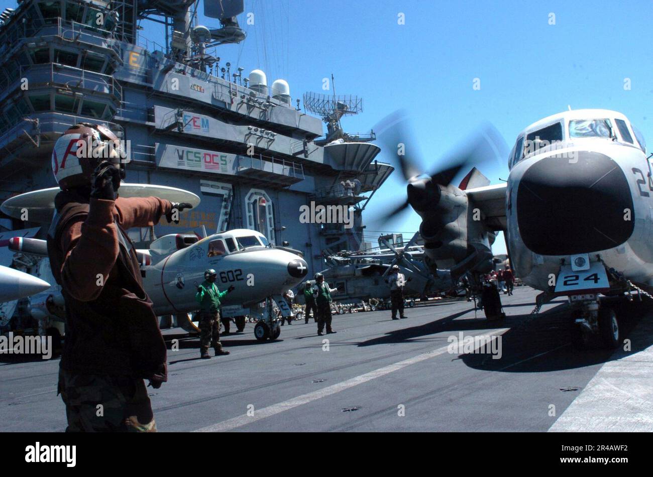 US Navy A plane captain signals the pilots of a C-2A Greyhound ...
