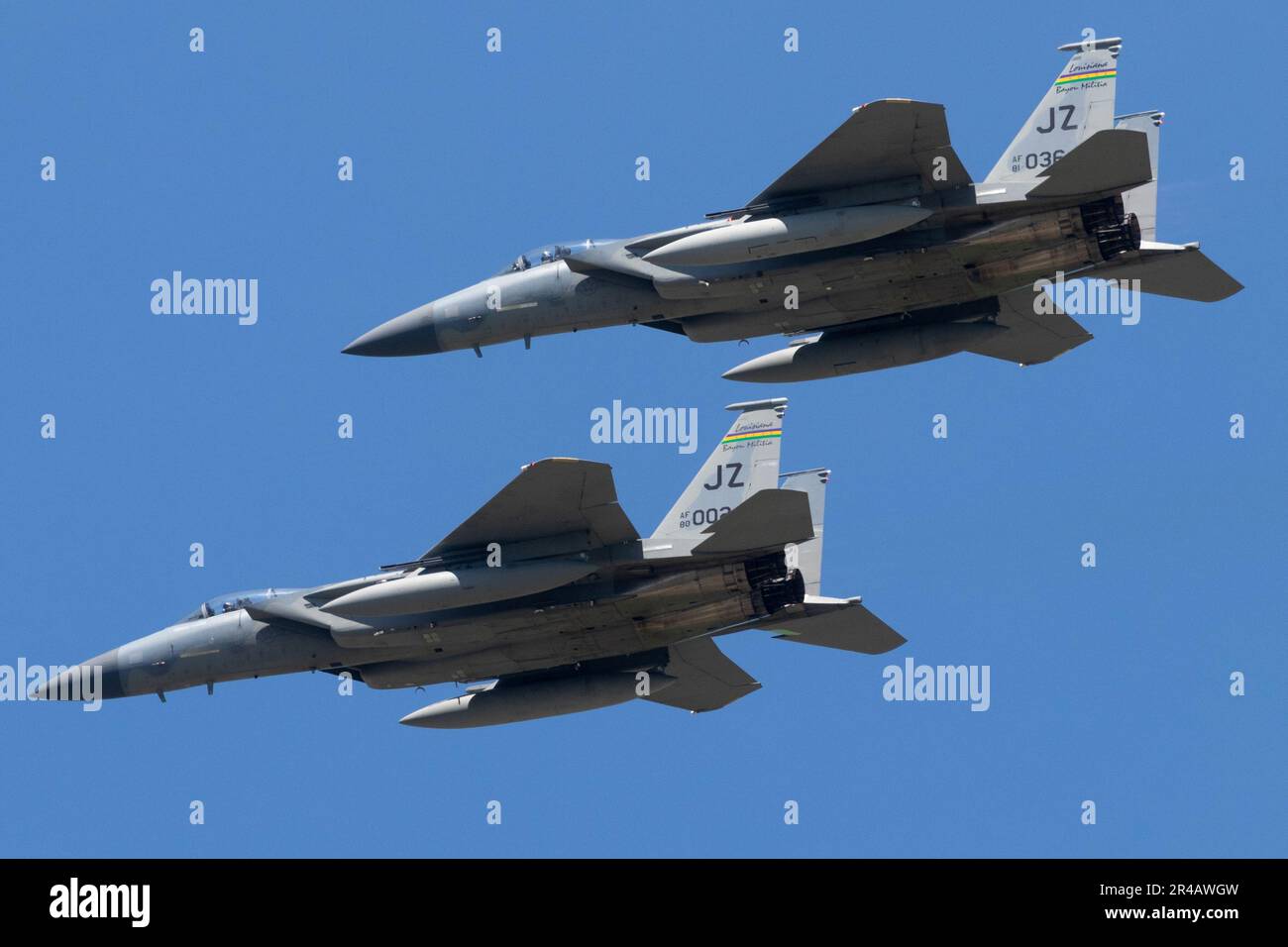 Two combat aircraft flying side by side in a clear blue sky, against a ...