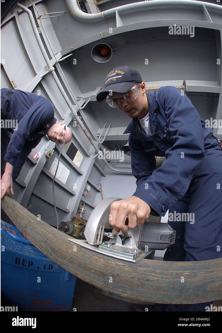 US Navy Damage Controlman Fireman cuts wood to be used for shoring ...
