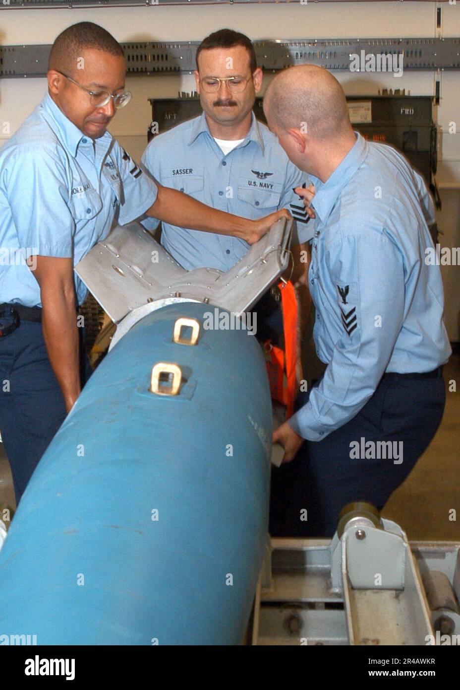 US Navy AO1 center, supervises AO1 right, and AO2 as they assemble and ...