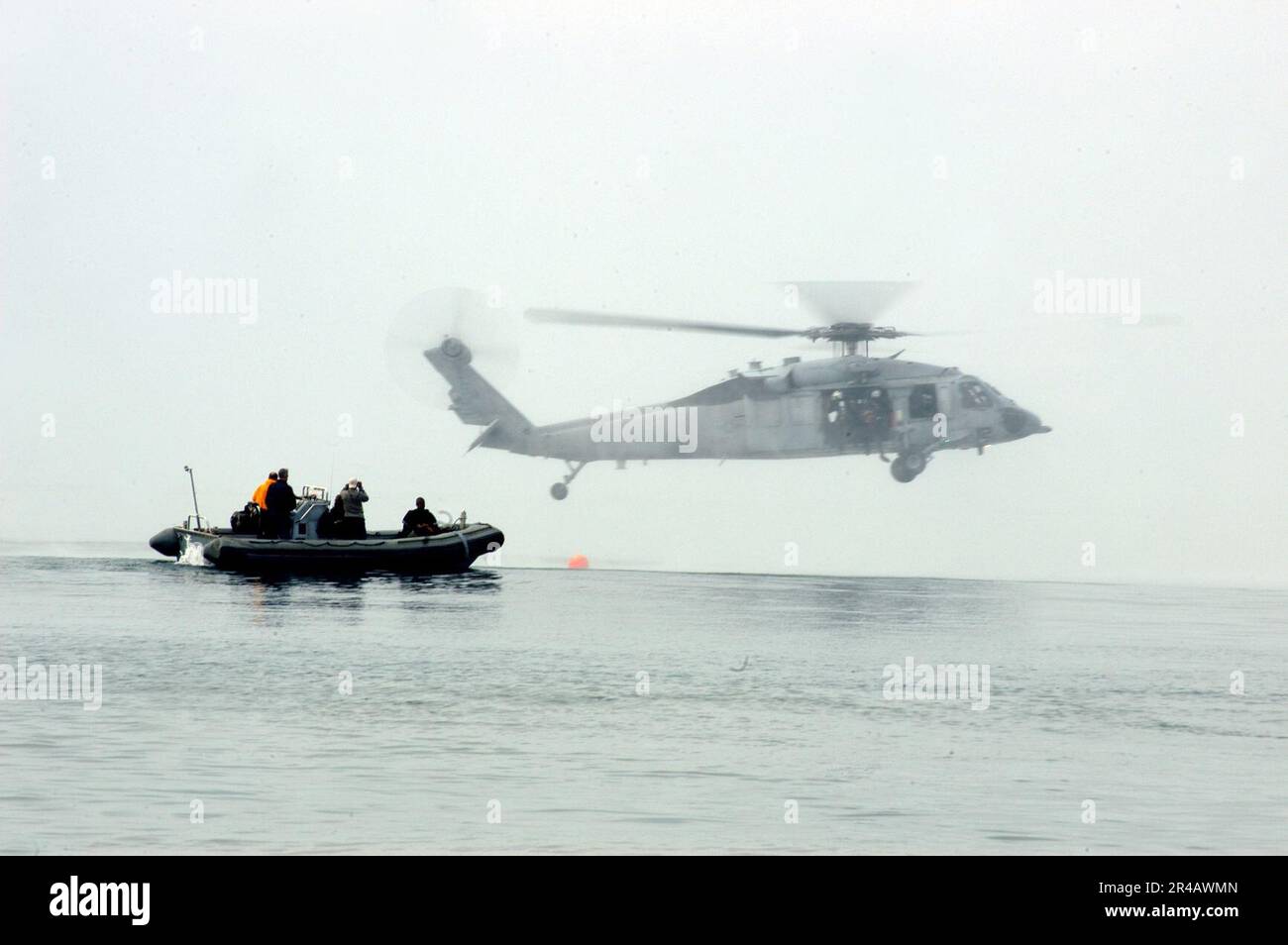 US Navy A MH-60S Seahawk helicopter hovers near a Rigid Hull Inflatable ...
