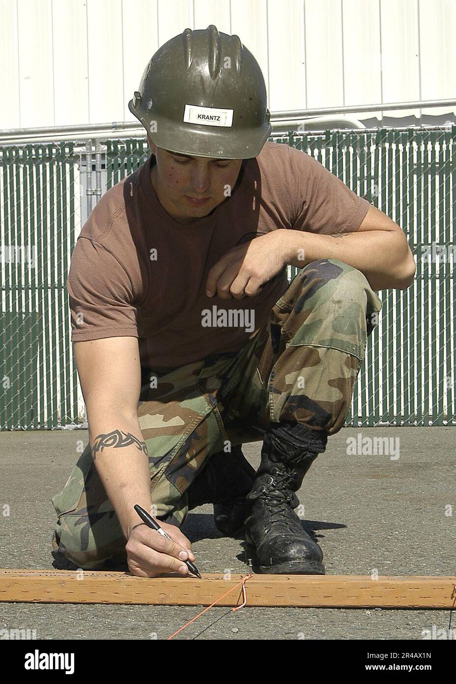 US Navy Utilitiesman Construction Apprentice marks out lumber that will ...