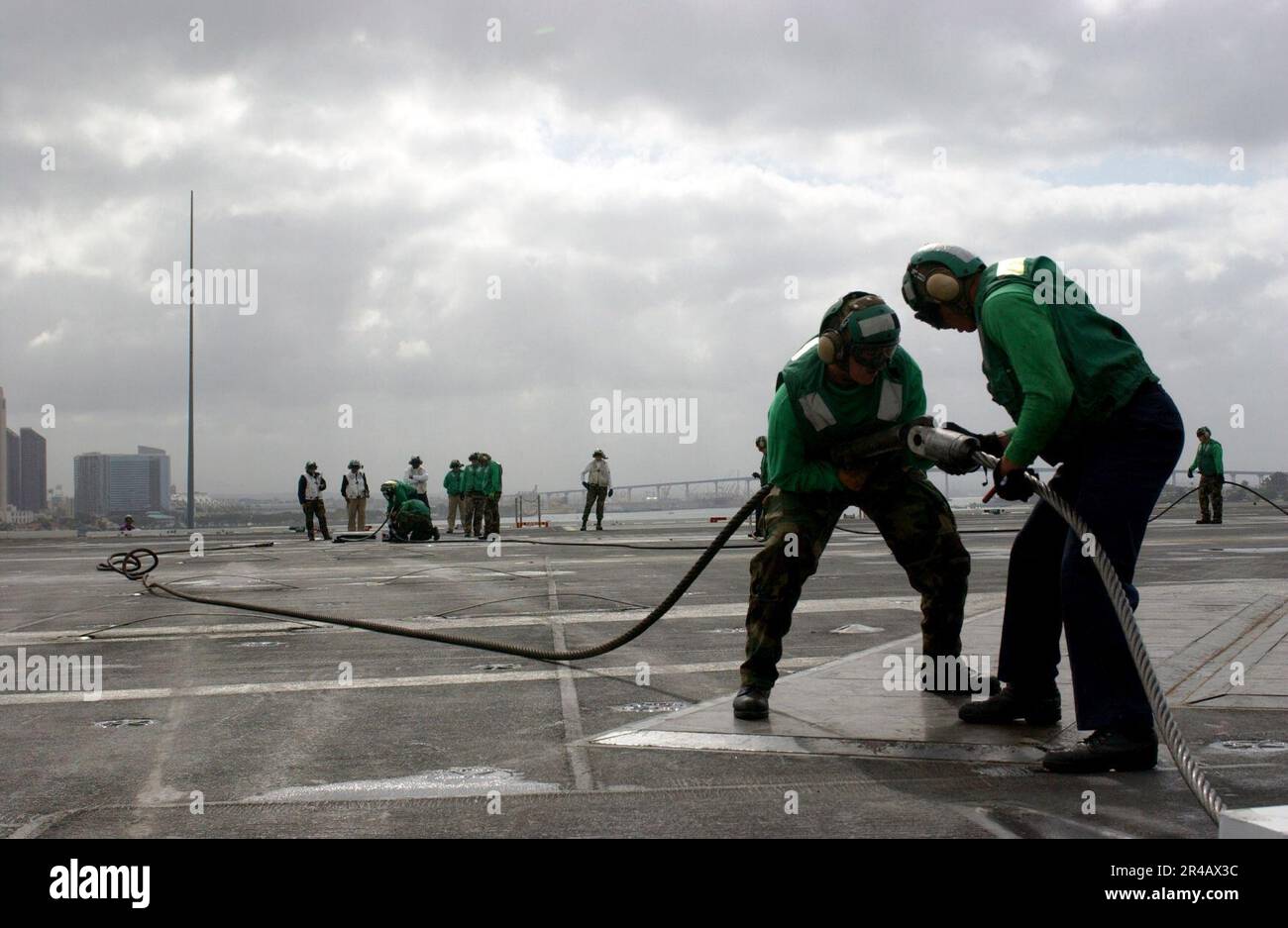 US Navy Arresting gear crew members, assigned to V-2 Division, replace ...