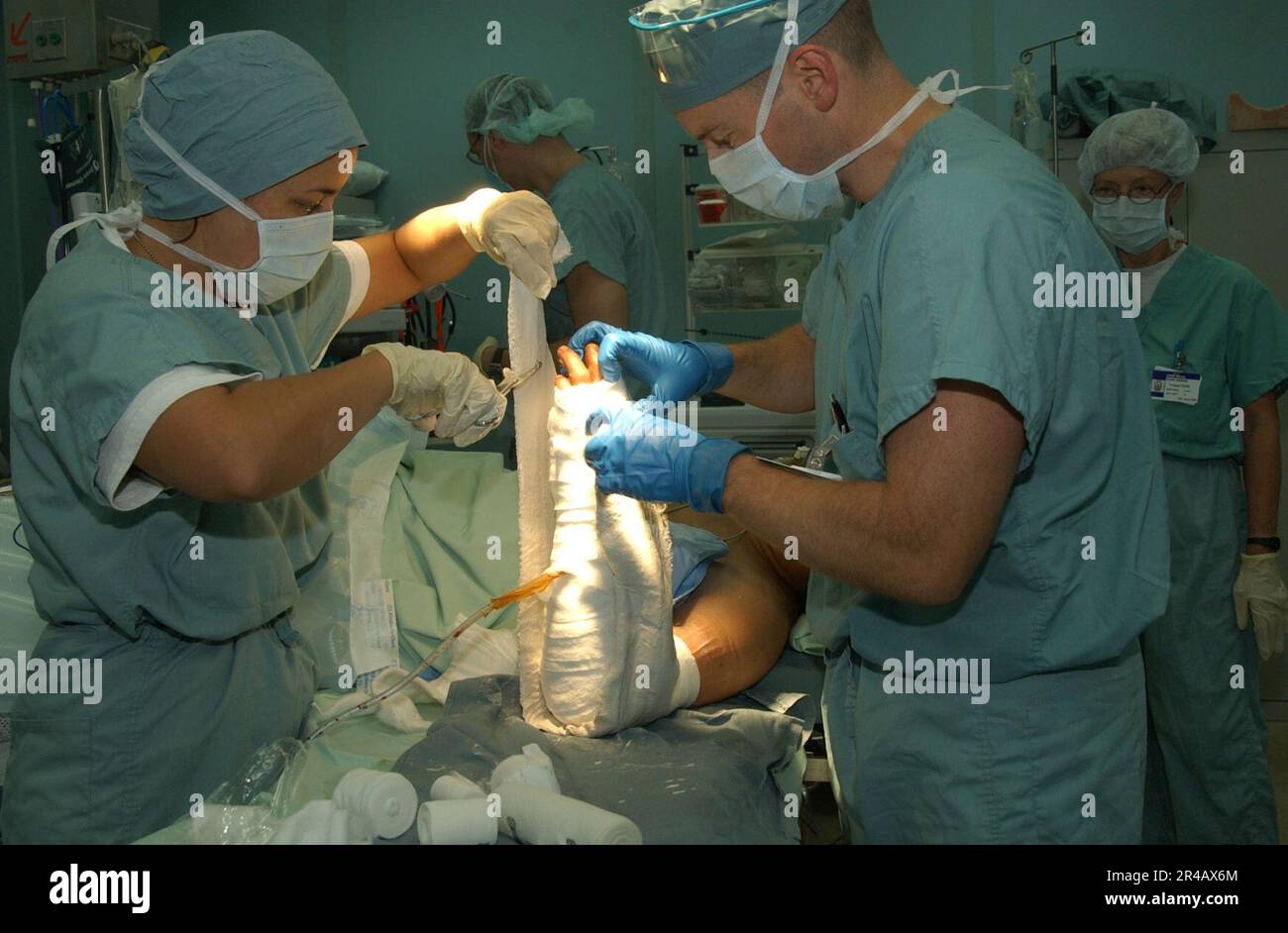 US Navy Lt. Cmdr. assists Hospital Corpsman 2nd Class as they place a ...