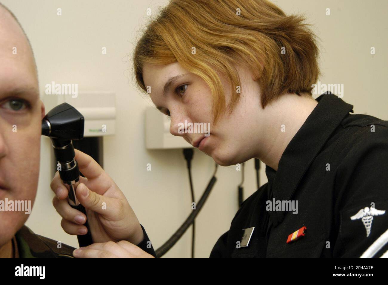 US Navy Hospitalman checks Hospital Corpsman 3rd Class ear during ...