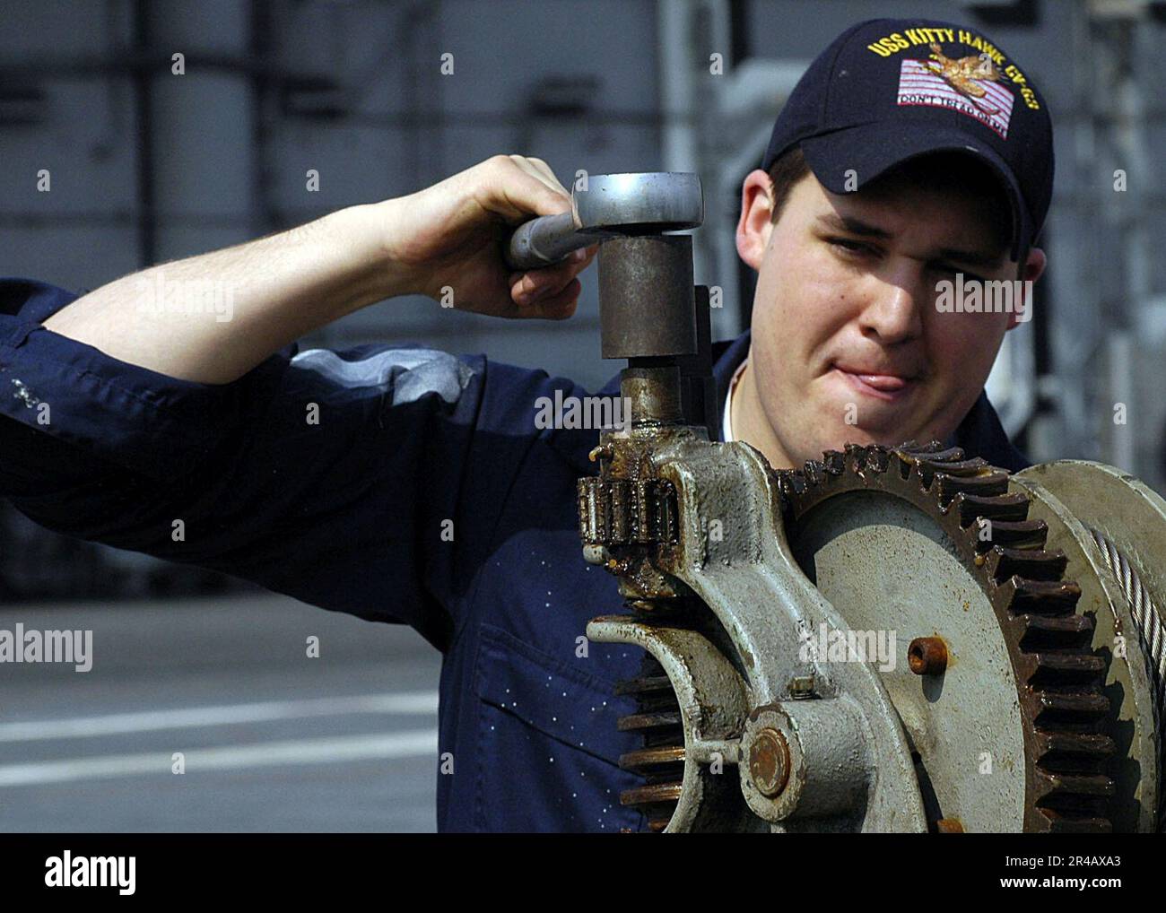 US Navy Airman helps lift a power cylinder from a steam-powered ...