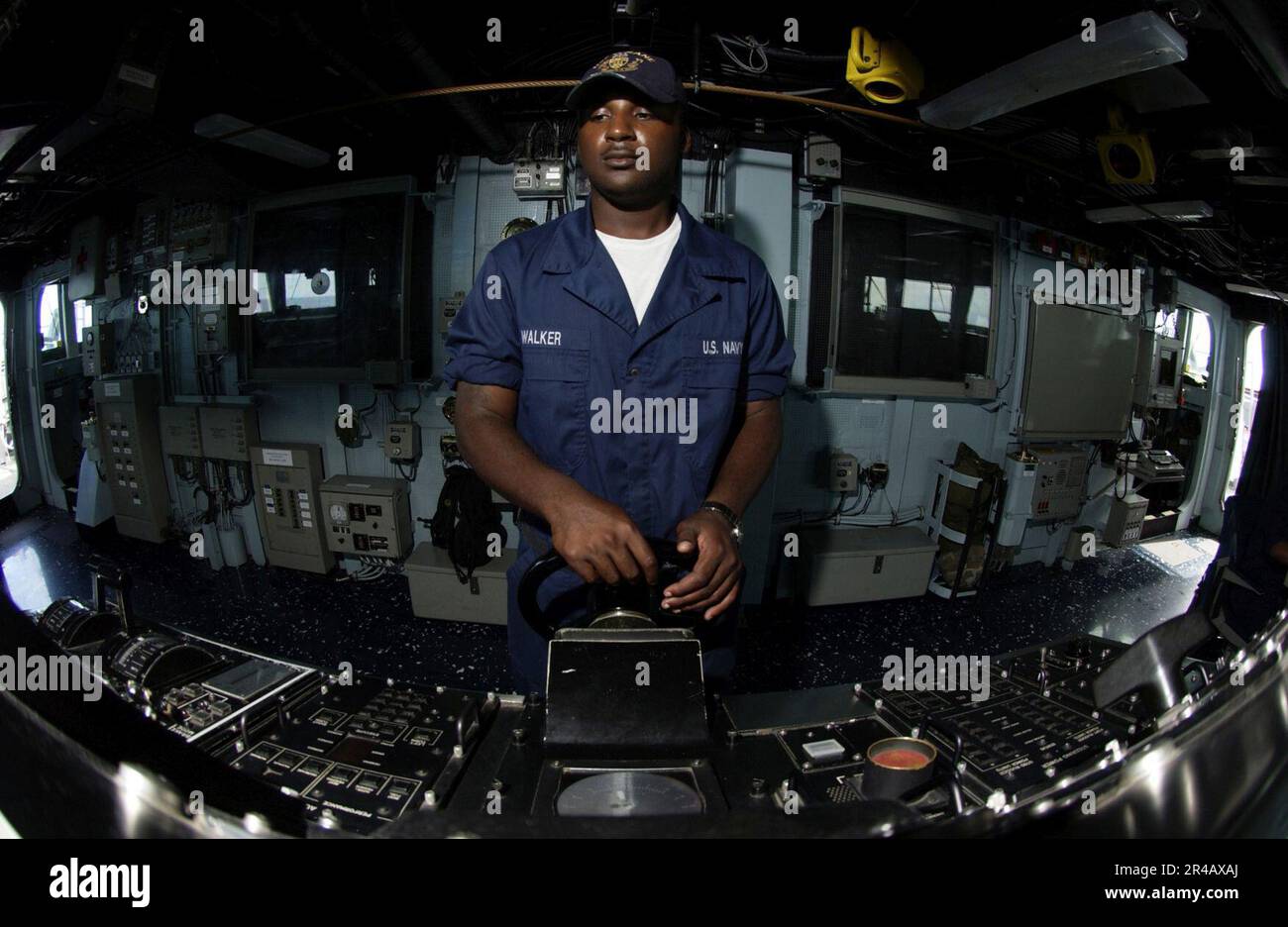US Navy Seaman stands the Helm Watch on the bridge aboard the guided ...