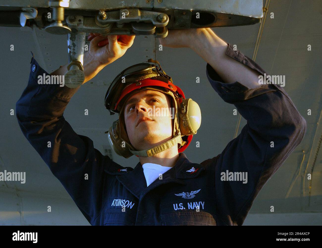 US Navy Aviation Ordnanceman 3rd Class checks the pylon on a P-3C Orion ...