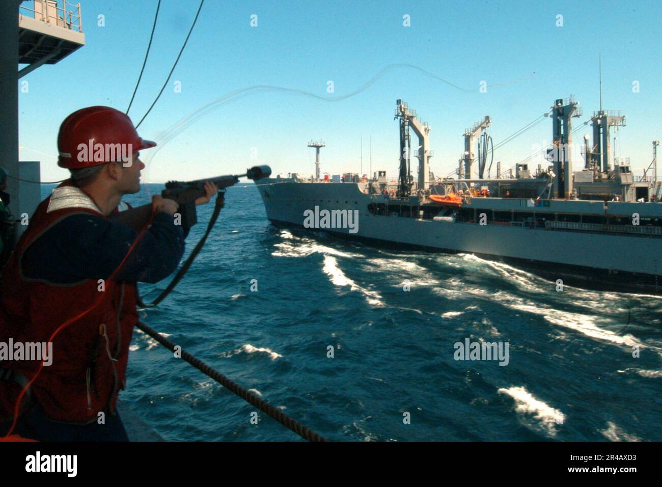 US Navy Gunner's Mate 3rd Class fires a shot line to the Military ...