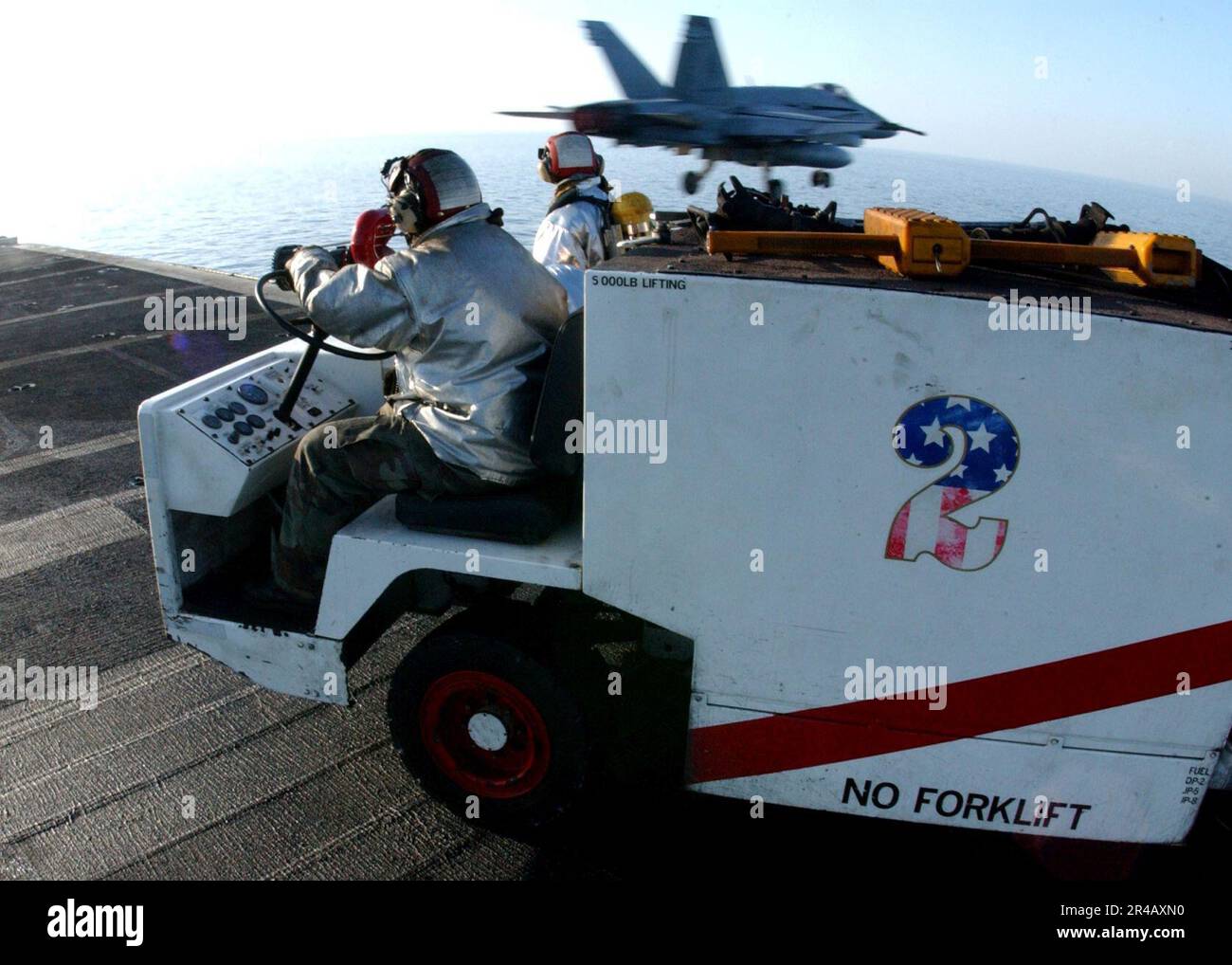 US Navy Crash and Salvage team members watch as an F-A-18C Hornet is ...