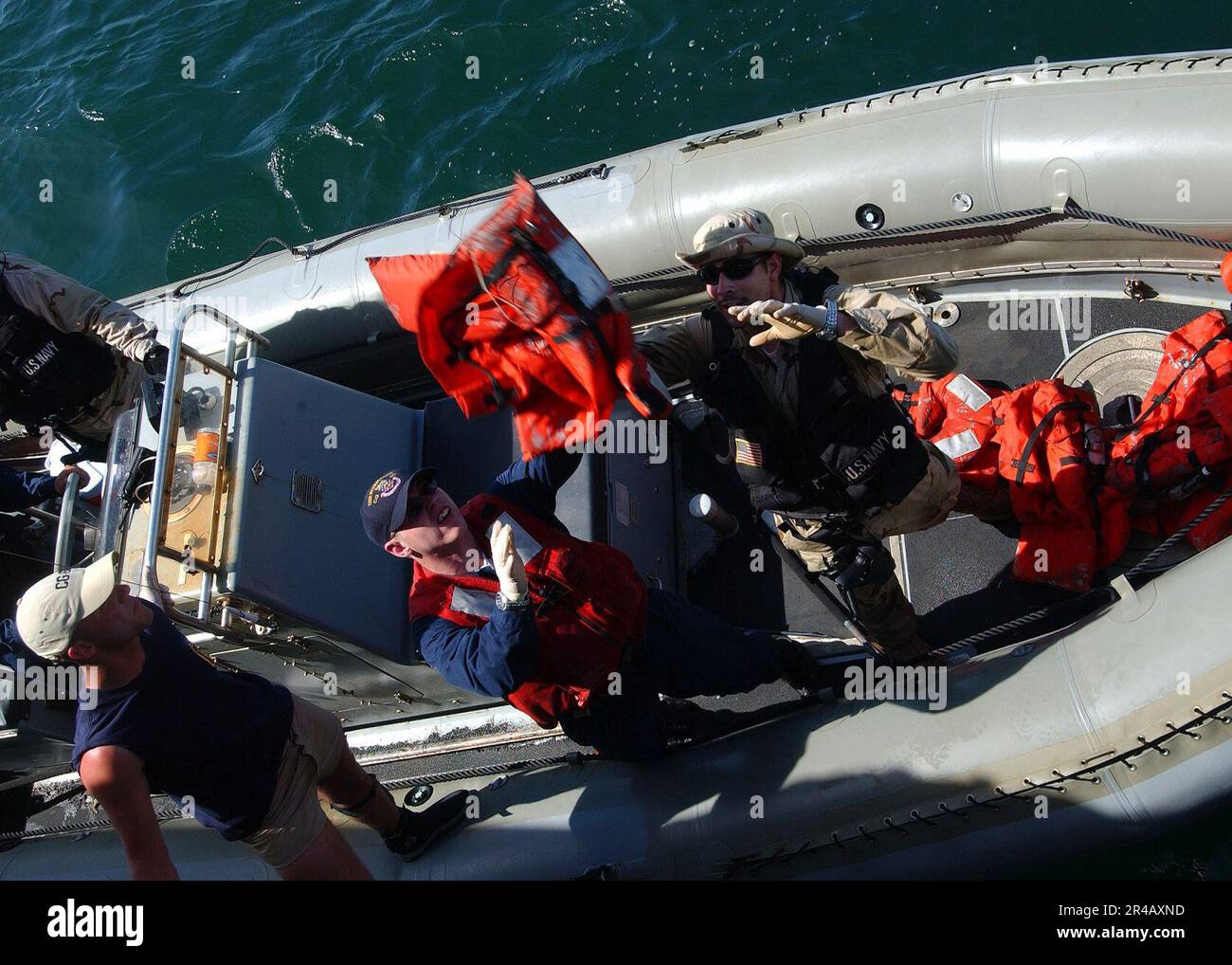 US Navy Sailors transfer men and women in a rigid hull inflatable boat ...