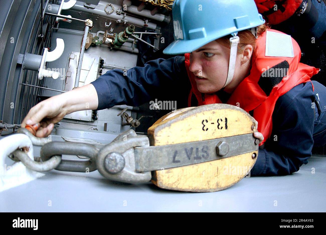 US Navy Seaman Texas, removes a snap block in the process of de-rigging ...