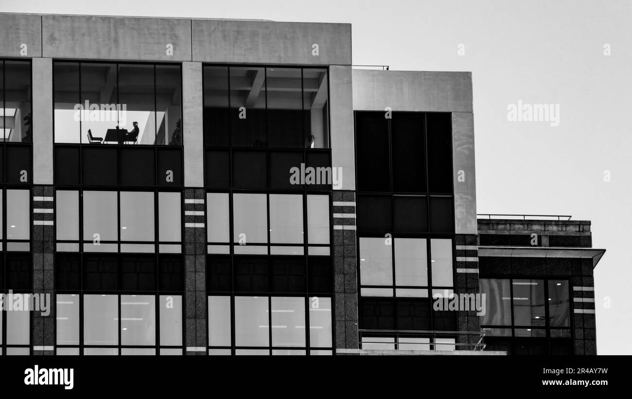 A three-story commercial building with large windows illuminated by the ...