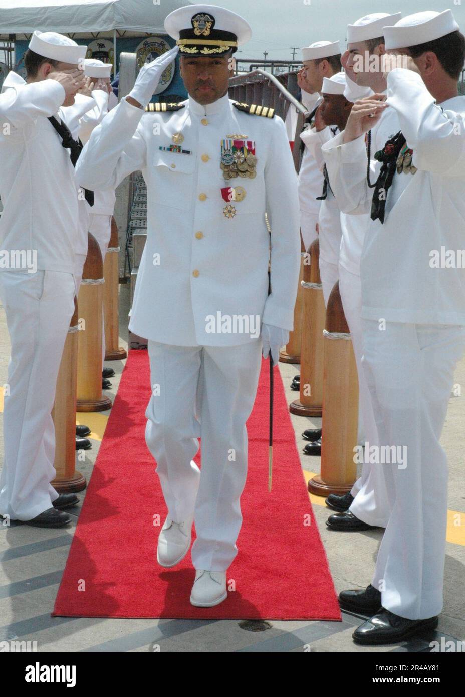 US Navy Capt. Bruce E. Grooms salutes the sideboys as he steps off the ...