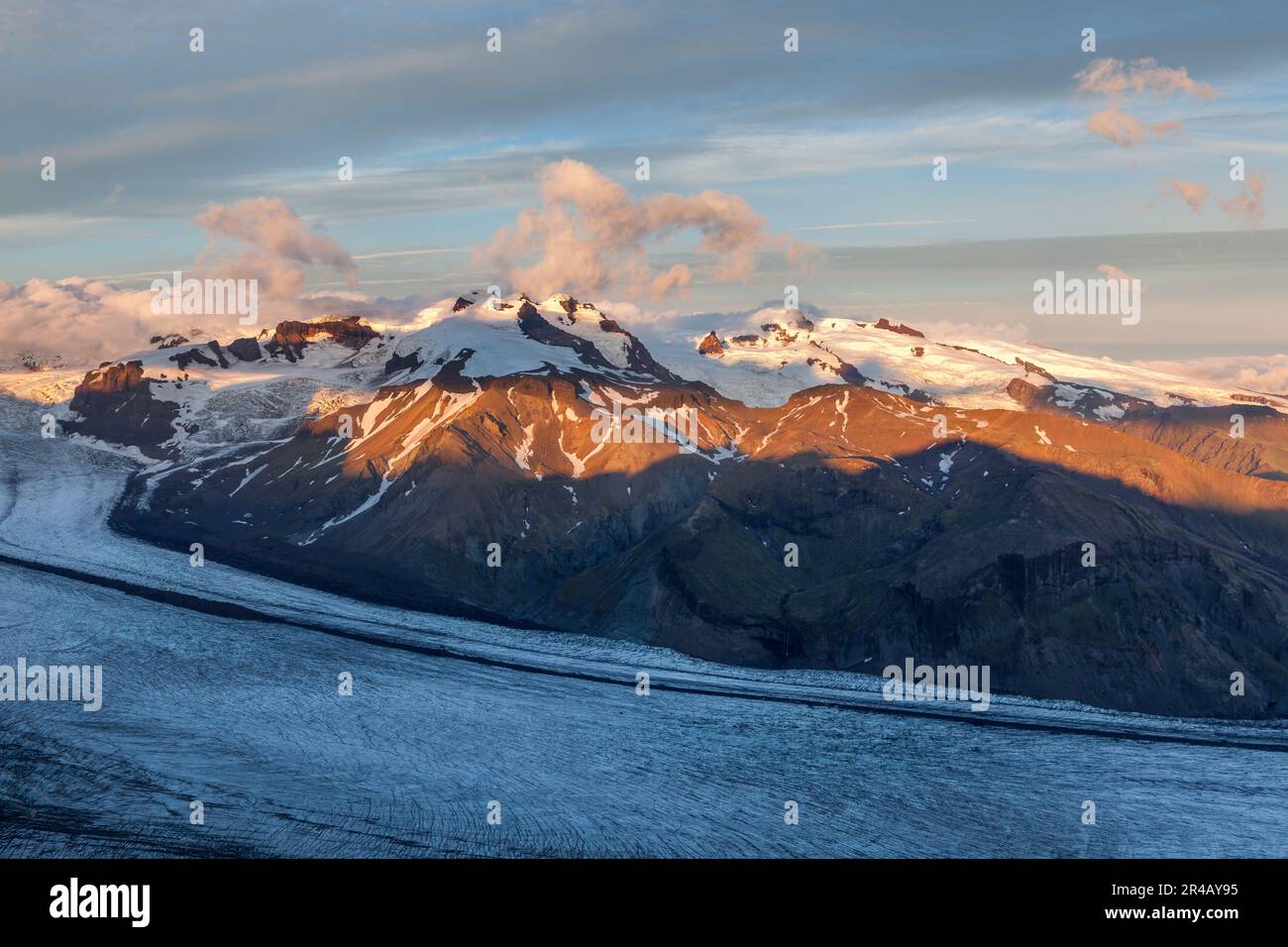 Glacier river flowing down the volcano mountain at sunset. Southern ...