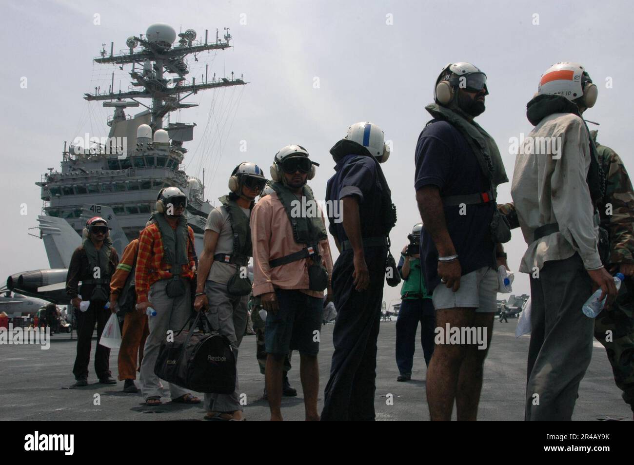 US Navy Motor Vessel Olympias crew members make their way across the flight deck aboard the ...
