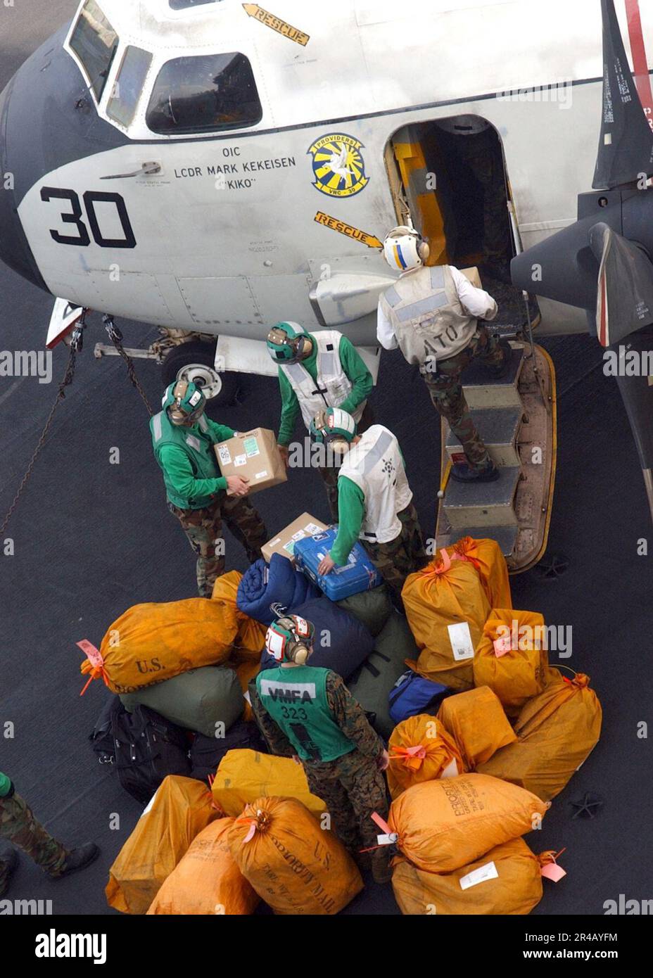 US Navy Sailors and Marines assist in loading off going mail onto a C ...
