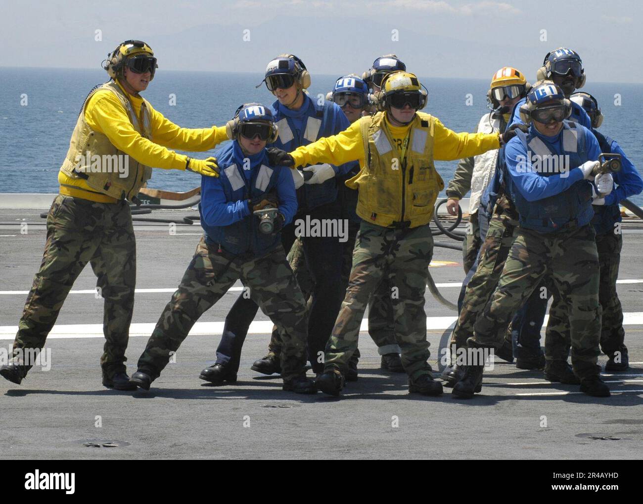 US Navy Air department Sailors man a 2.5-inch fire hose during an ...