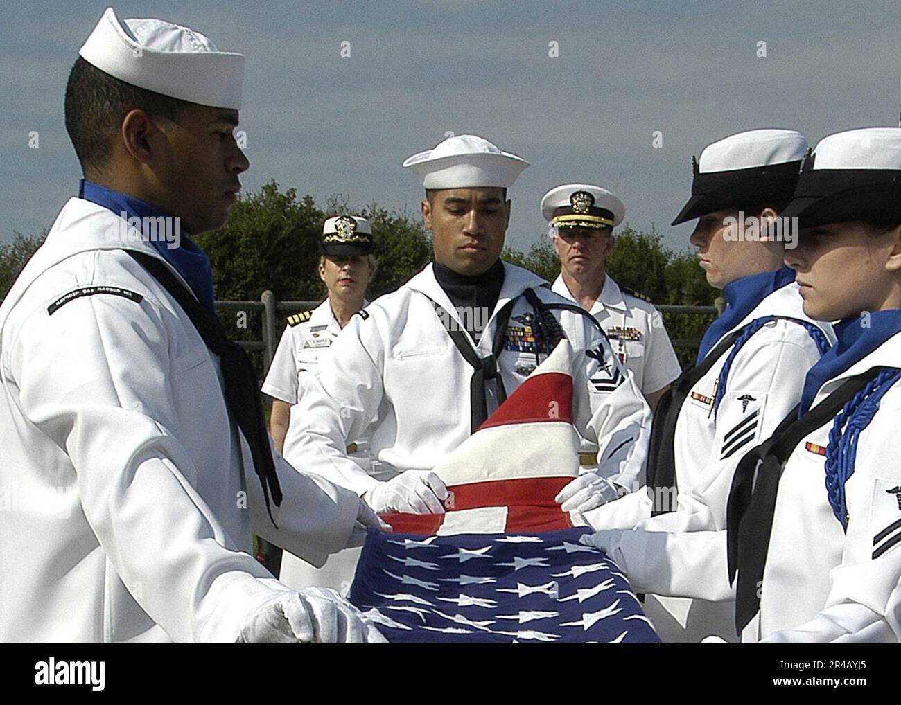 US Navy Sailors fold the American flag during Cdr. Michael Woelker's ...