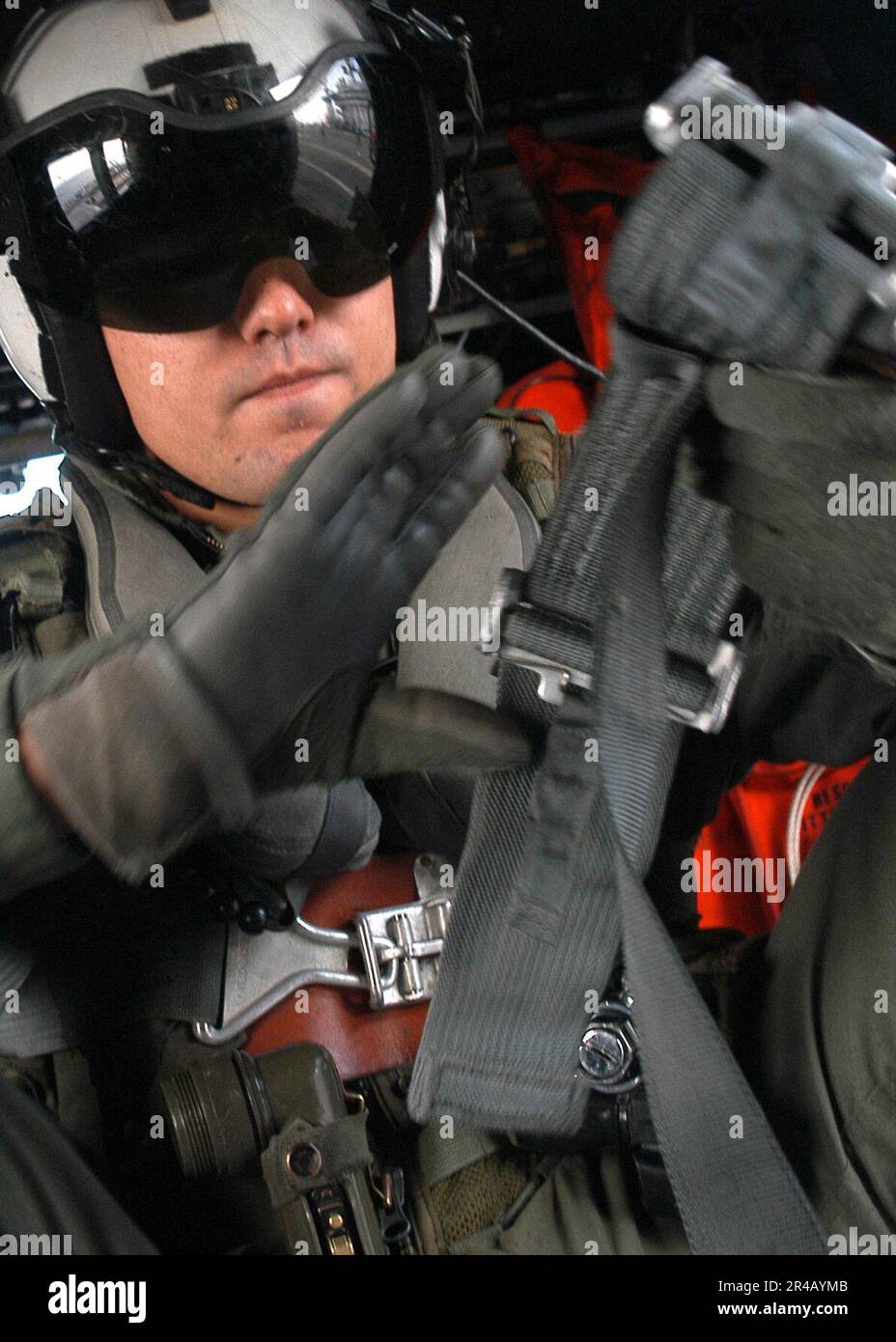 US Navy Aviation Warfare Specialist 2nd Class prepares a safety harness ...
