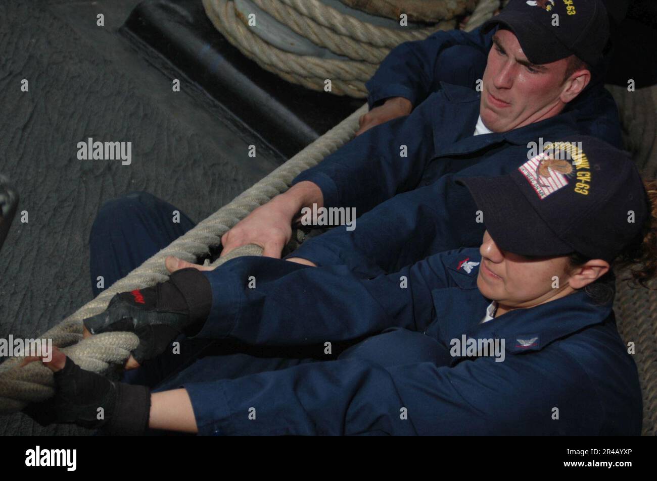 US Navy Seaman and Boatswain's Mate 3rd Class heave around a mooring ...