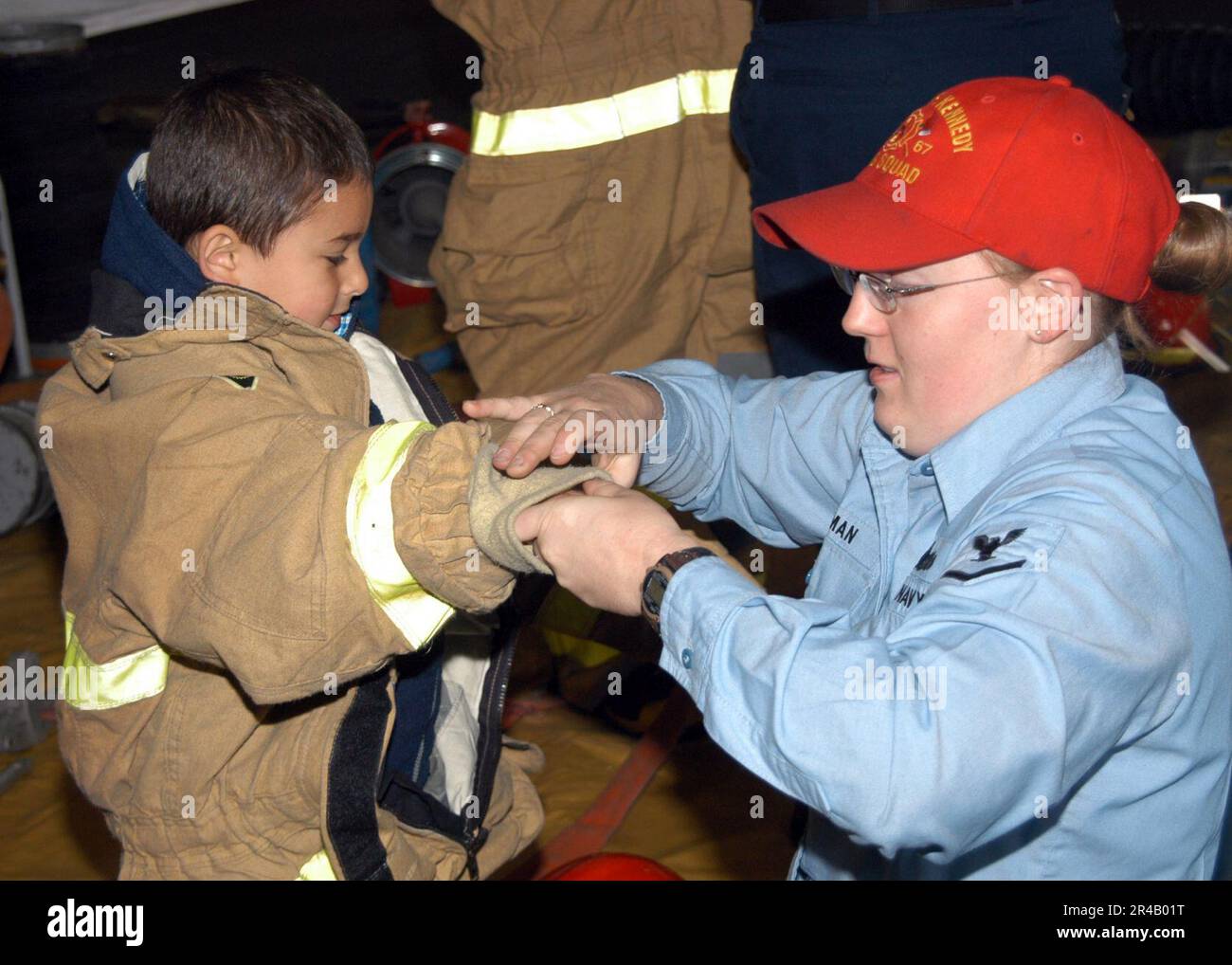 US Navy Damage Controlman 3rd Class shows children shipboard fire ...