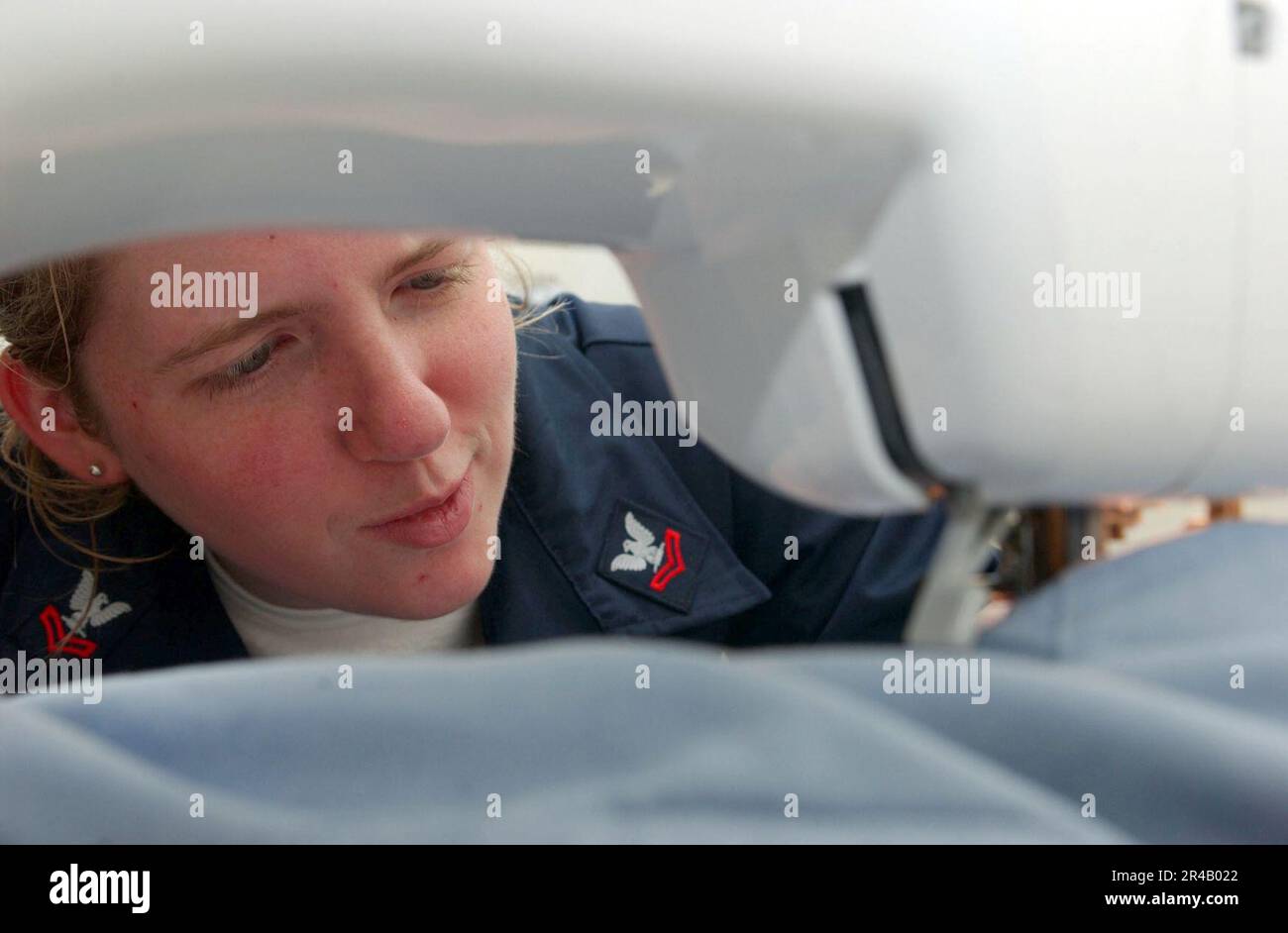 US Navy Electrician's Mate 2nd Class hems the inside of a pair of ...