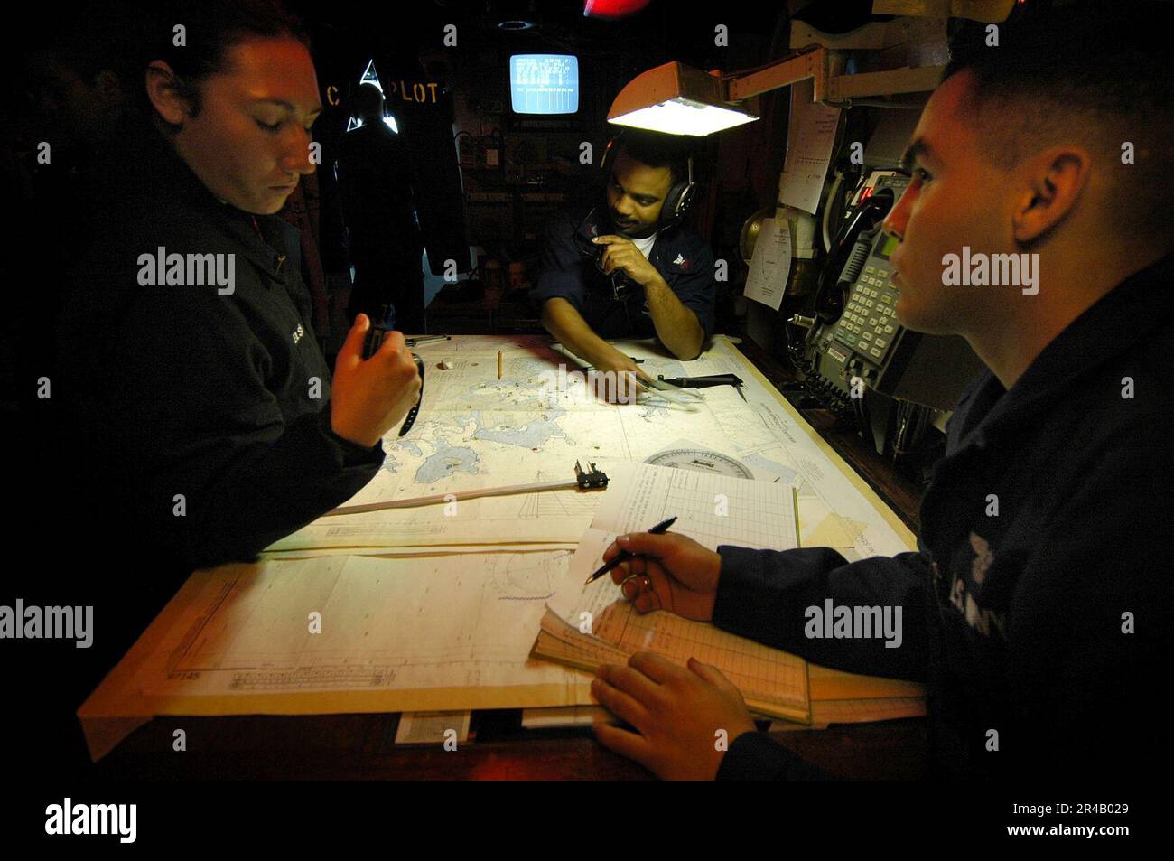 US Navy Operations specialists plot the transit course of USS Kitty ...