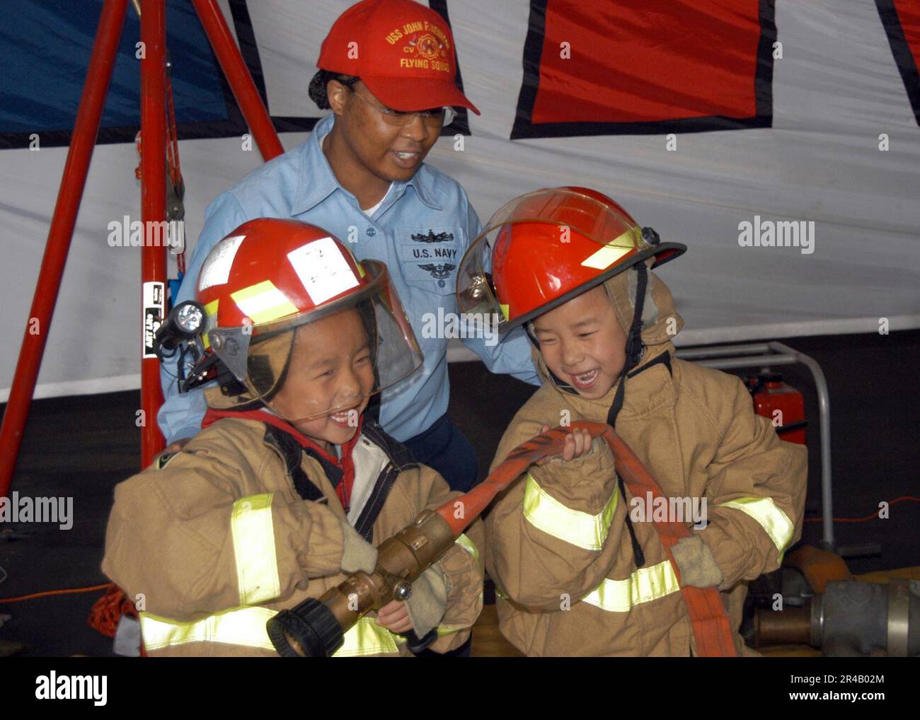 US Navy Damage Controlman 2nd Class shows children shipboard fire ...