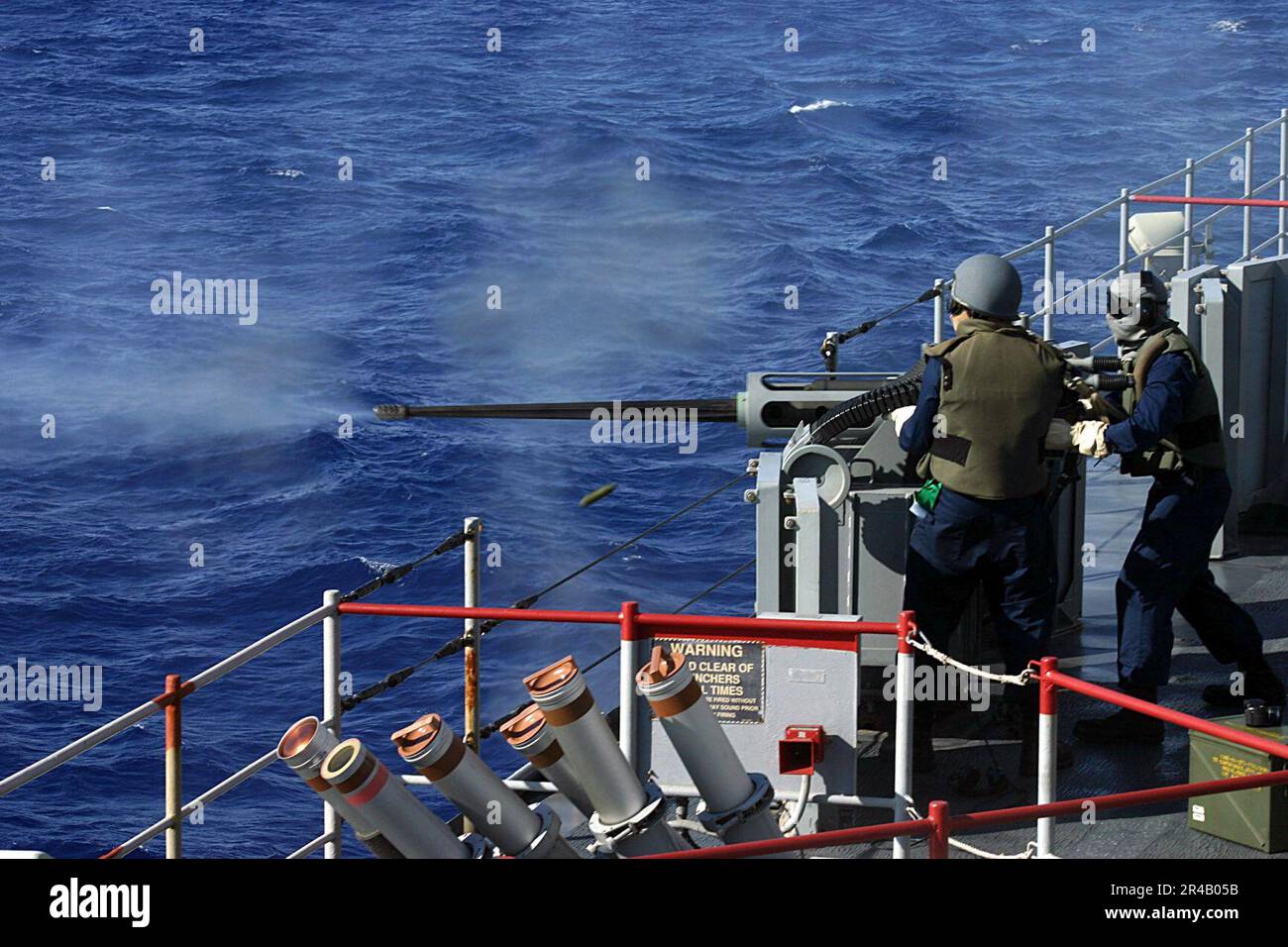 US Navy Gunner's Mate 2nd Class fires a MK-38 25mm machine gun off the ...