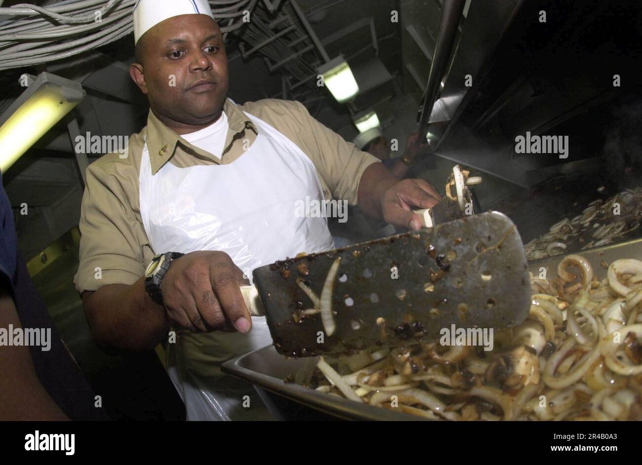 US Navy Culinary Specialist Chief Petty Officer prepares dinner for the ...