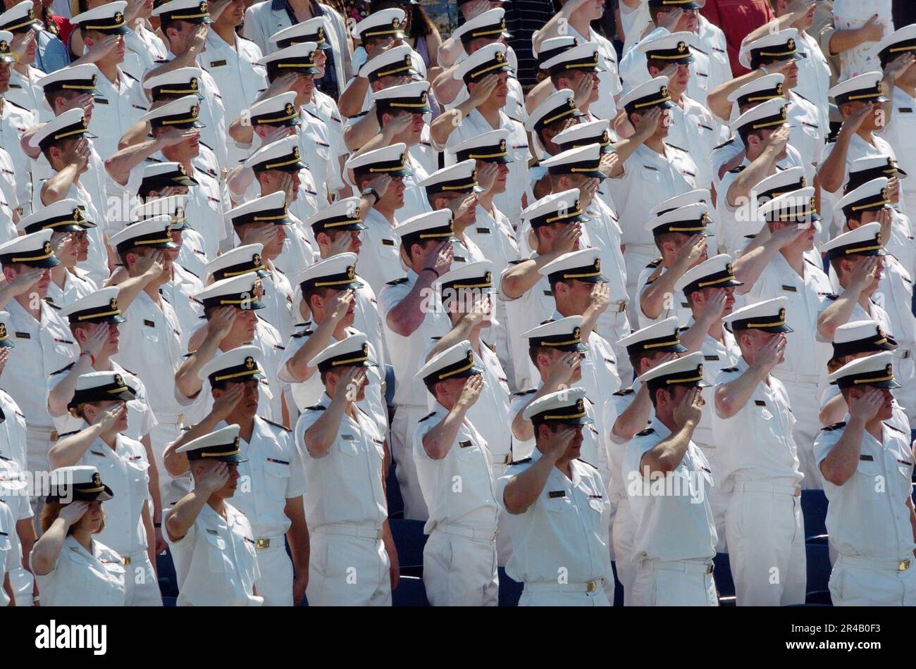 US Navy U.S. Naval Academy Midshipmen salute during the National Anthem ...