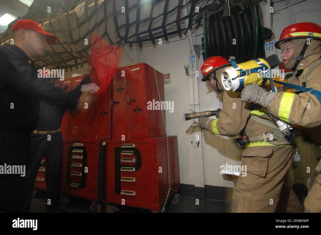US Navy A damage control training team member simulates flames using a ...