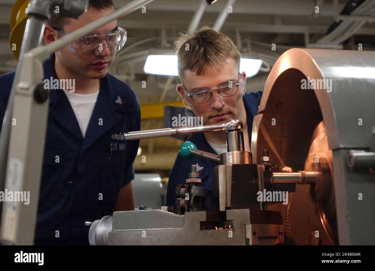 US Navy Machinist Mate 3rd Class left, observes Machine Repairman 2nd ...