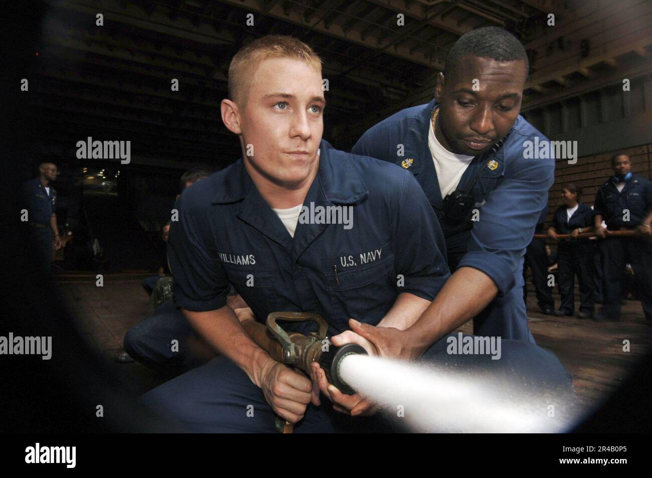 US Navy Chief Damage Controlman provides proper hose handling ...