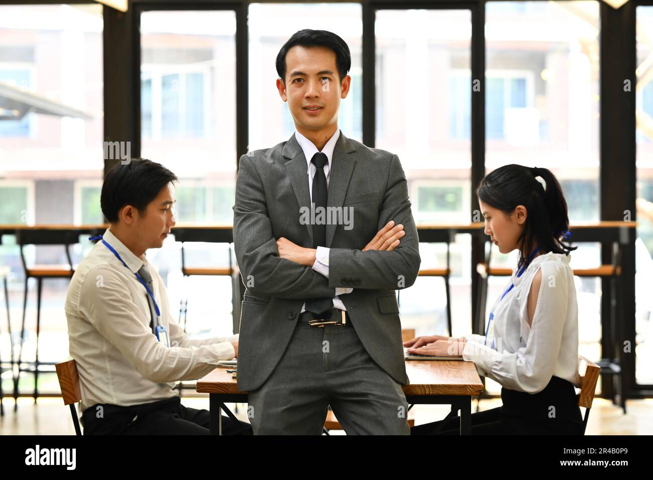 Portrait of confident asian male executive in suit standing with ...