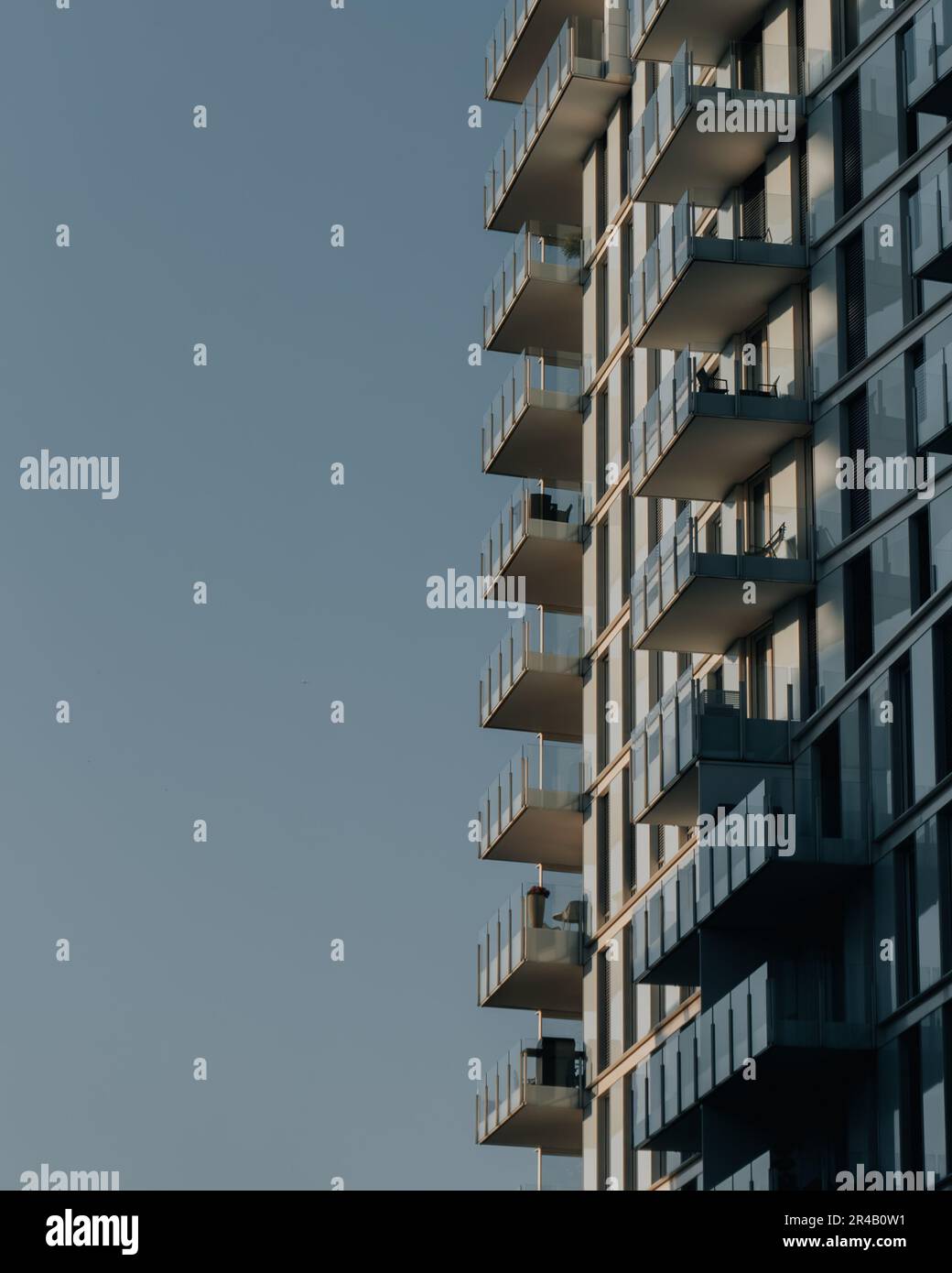 A large, modern high-rise building with multiple balconies and windows ...