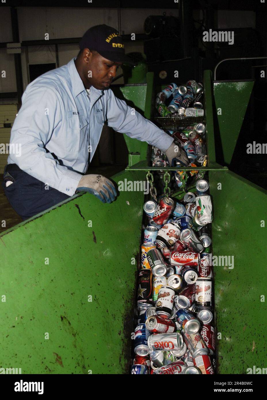 US Navy Fireman separates bottles from aluminum cans at the Navy ...