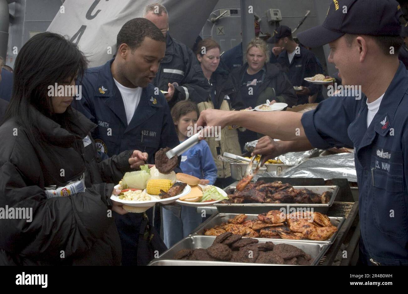 US Navy Culinary Specialist 2nd Class serves food to crew members and ...